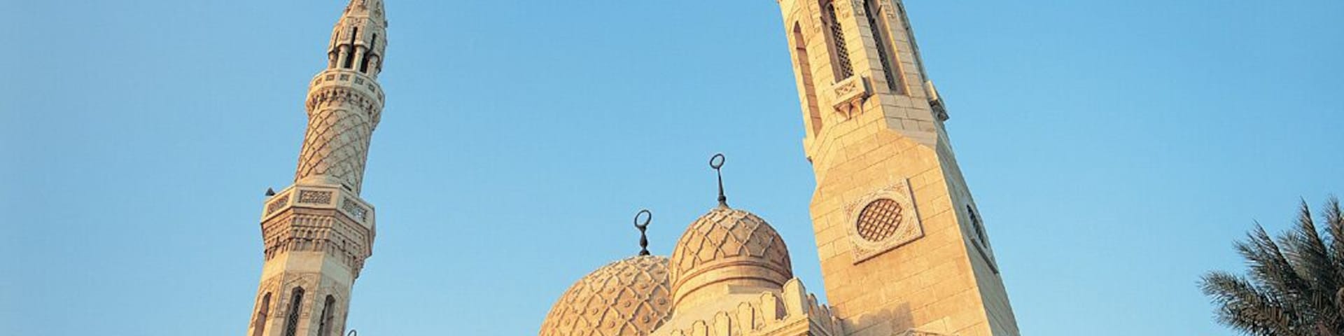 Uma mesquita com duas torres altas e uma cúpula grande.