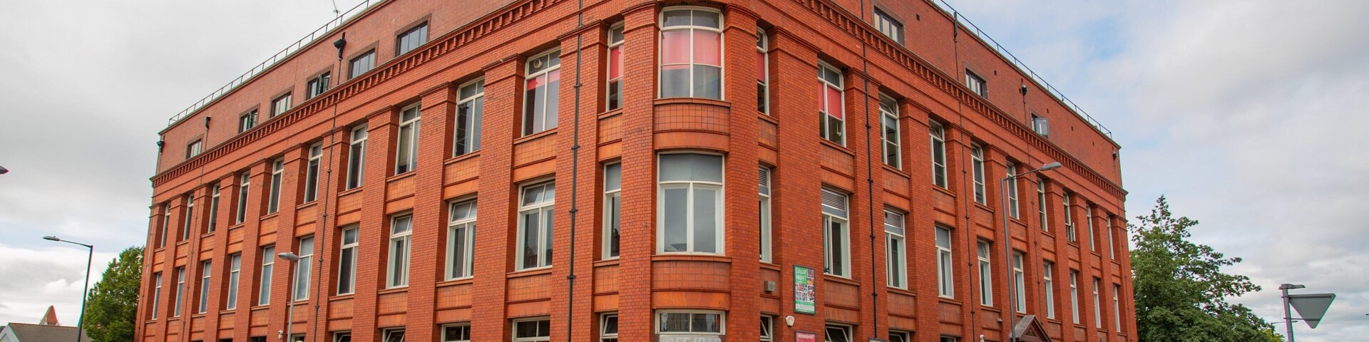 Um edifício de tijolos vermelhos com um café/bar no andar térreo.
