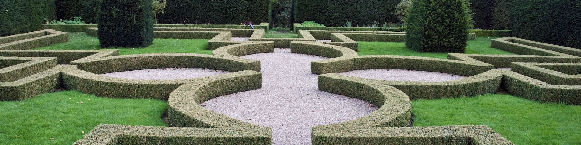 Little Moreton Hall is a moated 15th and 16th-century half-timbered manor house 4 miles (6.4 km) southwest of Congleton, Cheshire. It is one of the finest examples of timber-framed domestic architecture in England. The house is today owned by the National Trust. It has been designated by English Heritage as a Grade I listed building, and is protected as a Scheduled Monument. So picturesque is the house that it has been described as "a ginger bread house lifted straight from a fairy story". The earliest parts of the house were built for the prosperous Cheshire landowner Sir Richard de Moreton around 1450; the remainder was constructed in various campaigns by three successive generations of the family until around 1580. The house remained in the ownership of the Moreton family for almost five centuries. The building is highly irregular, with asymmetrical façades that ramble around three sides of a small cobbled courtyard, with "bays and porches jostling each other for space".