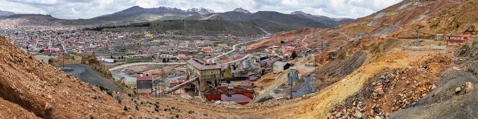 Uma operação de mineração com uma cidade no vale, rodeada por montanhas.