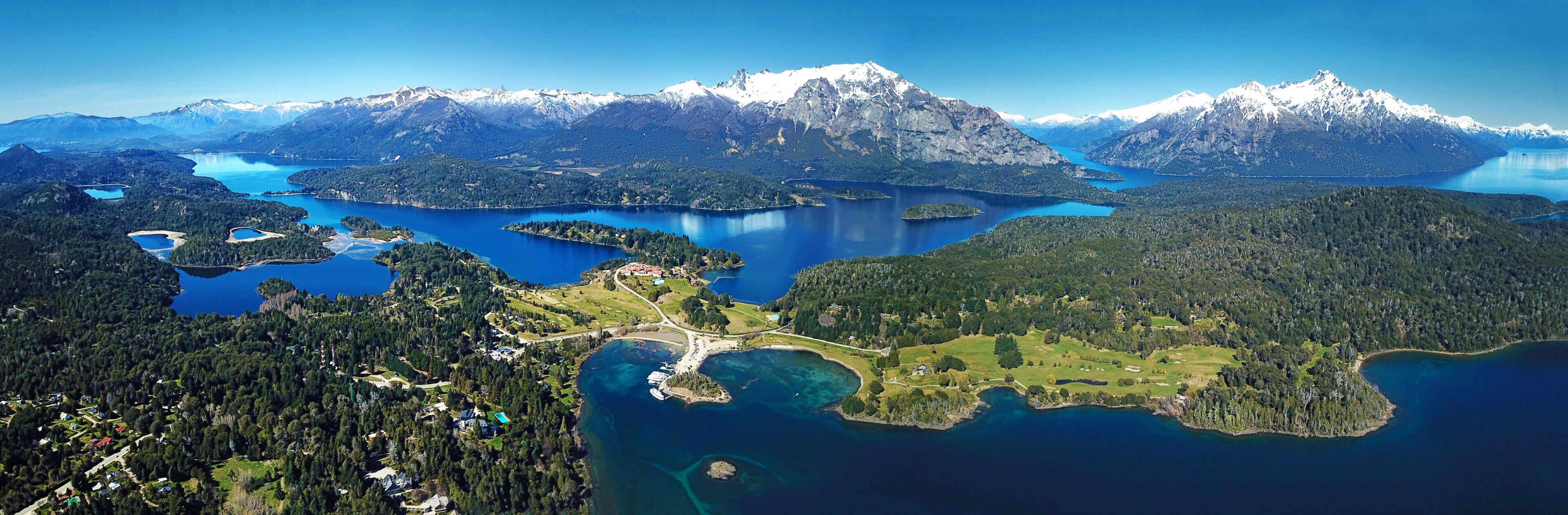 Paisagem montanhosa com vários lagos e uma floresta densa.