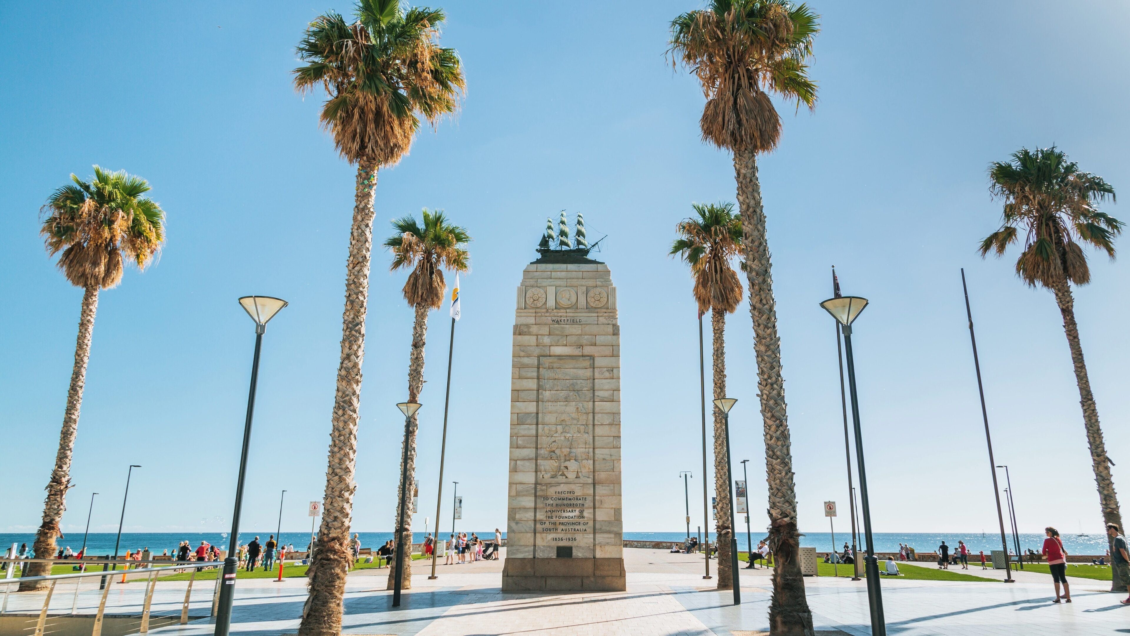 Visit Glenelg Beach in Adelaide, South Australia to enjoy sun, sand, and relaxation by the calm waters on a bright, sunny day