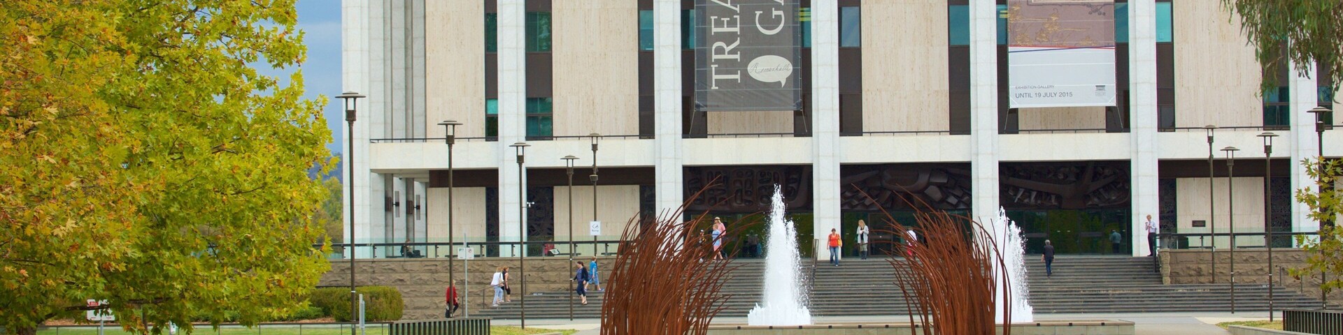 Um edifício com uma placa que diz 'Treasures Gallery' e uma fonte em frente.