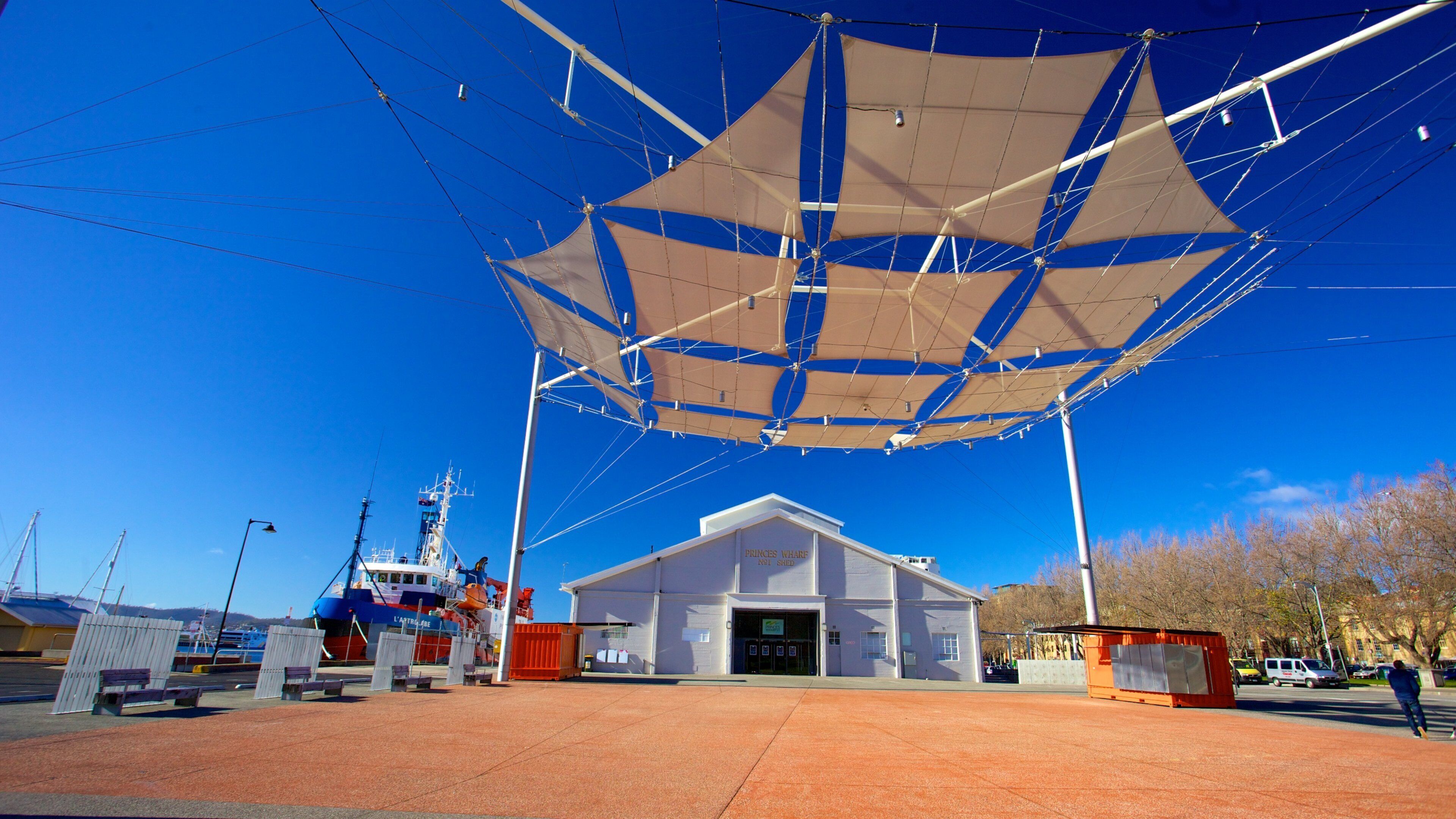 Uma grande estrutura em forma de vela, um edifício com a inscrição 