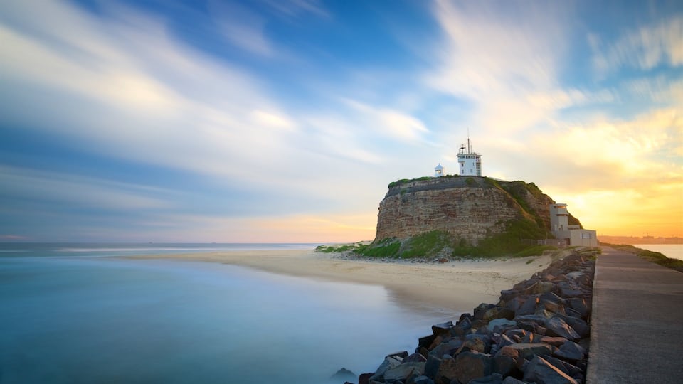 Nobbys Head Beach which includes rocky coastline, a lighthouse and a bay or harbor