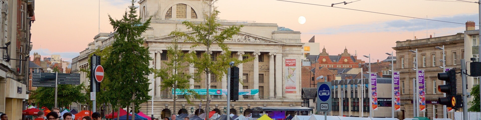 Uma rua movimentada com um edifício grande e uma cúpula ao fundo.