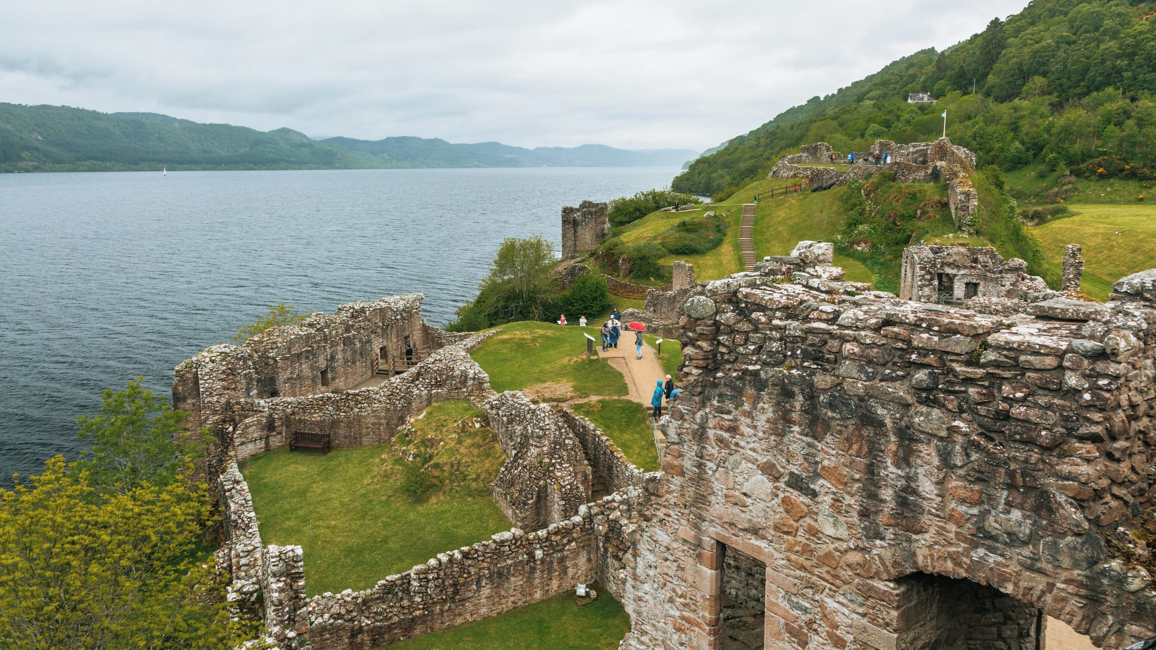 Exploring the historic Urquhart Castle ruins overlooking Loch Ness in Inverness, Scotland during a cloudy day