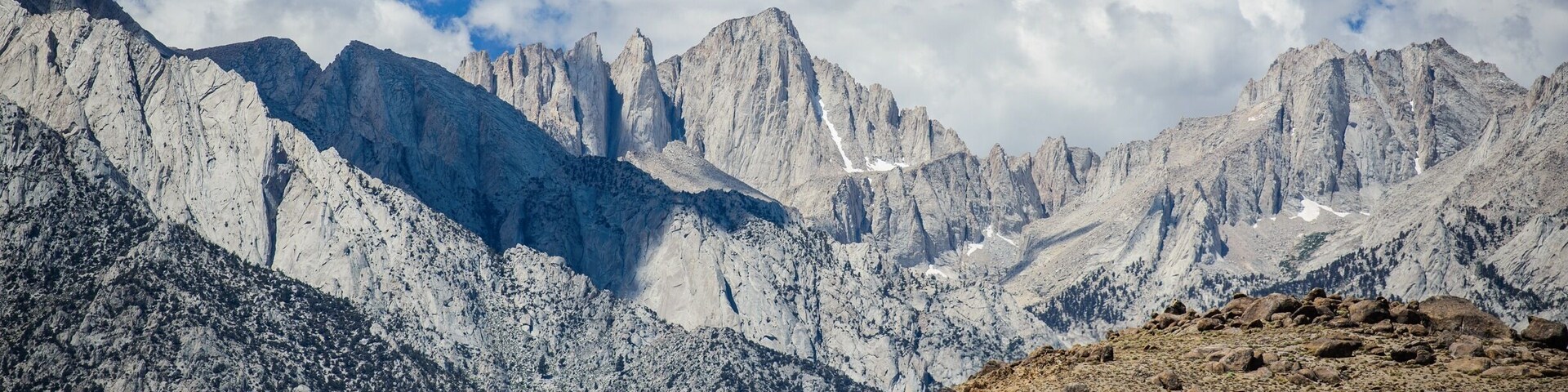 Uma cordilheira acidentada com picos afiados e um céu azul límpido.