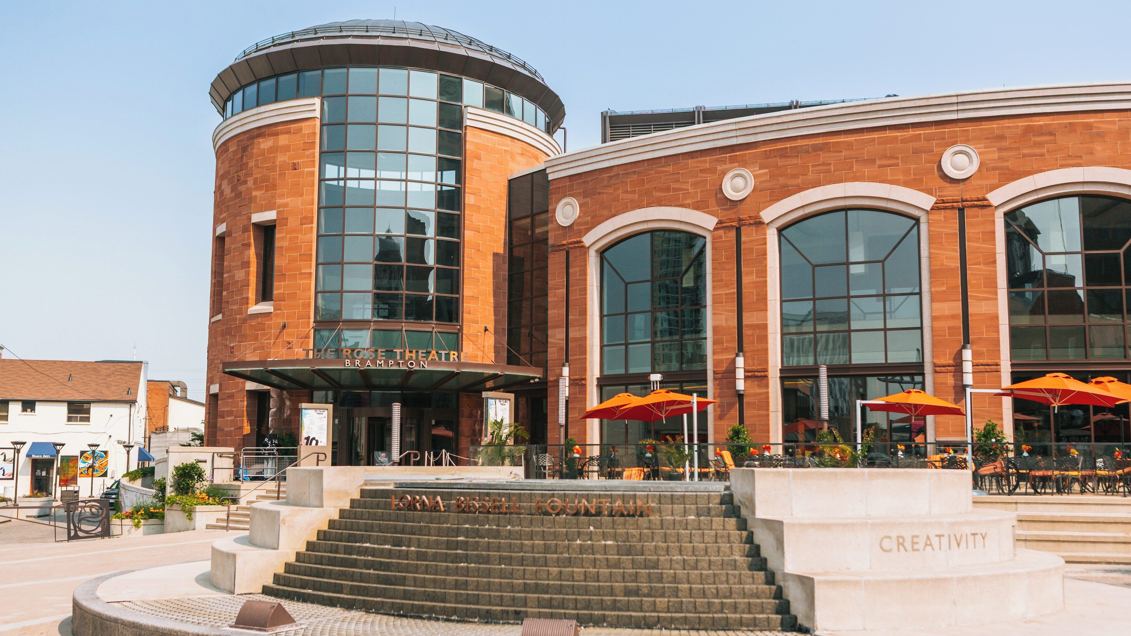 Rose Theatre located in Brampton, Ontario, showcases modern architecture and vibrant outdoor seating for visitors enjoying performances and events