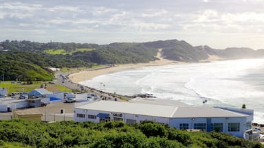 Uma cidade costeira com praia, estacionamento e edifícios.