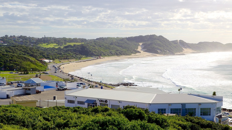 Uma cidade costeira com praia, estacionamento e edifícios.