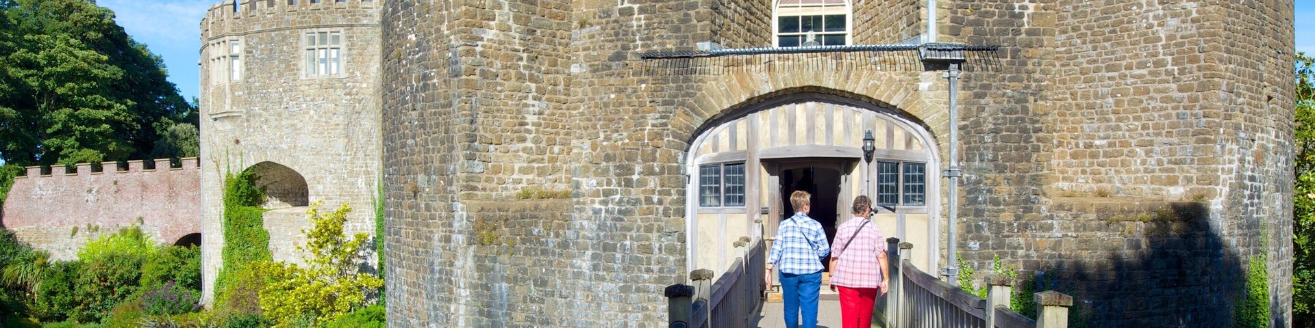 Walmer Castle and Gardens que inclui uma ponte e um castelo assim como um pequeno grupo de pessoas