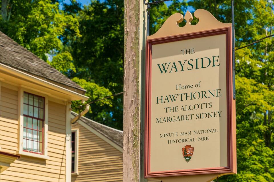 Placa com o texto: 'The Wayside, Lar de Hawthorne, dos Alcotts, Margaret Sidney, Parque Histórico Nacional do Minute Man'.