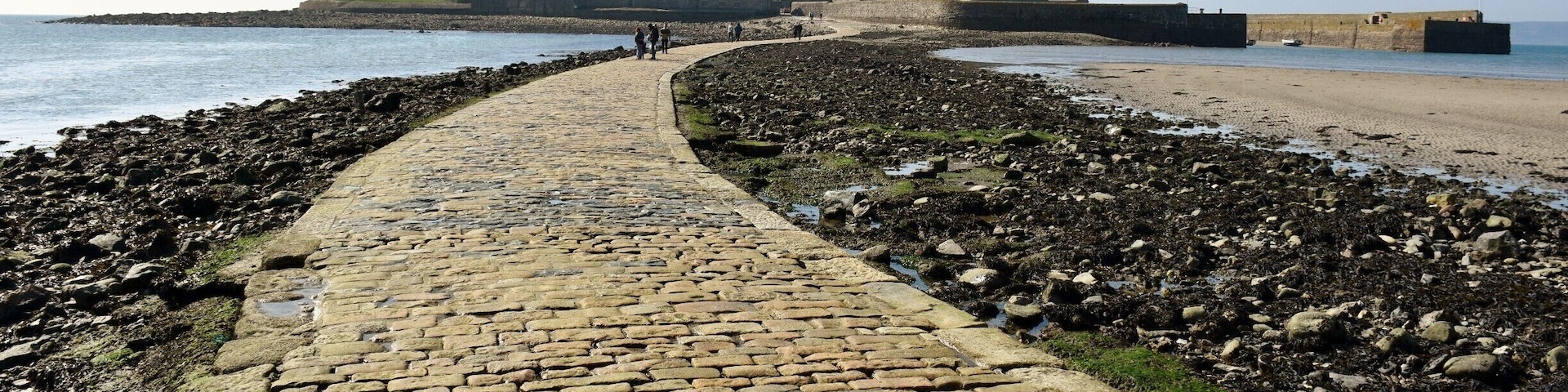 St Michael's Mount (Cornish: Karrek Loos yn Koos,[meaning "hoar rock in woodland") is a small tidal island in Mount's Bay, Cornwall, England, United Kingdom. The island is a civil parish and is linked to the town of Marazion by a man-made causeway of granite setts, passable between mid-tide and low water. The population of this parish in 2011 was 35. It is managed by the National Trust, and the castle and chapel have been the home of the St Aubyn family since approximately 1650. The earliest buildings, on the summit, date to the 12th centur