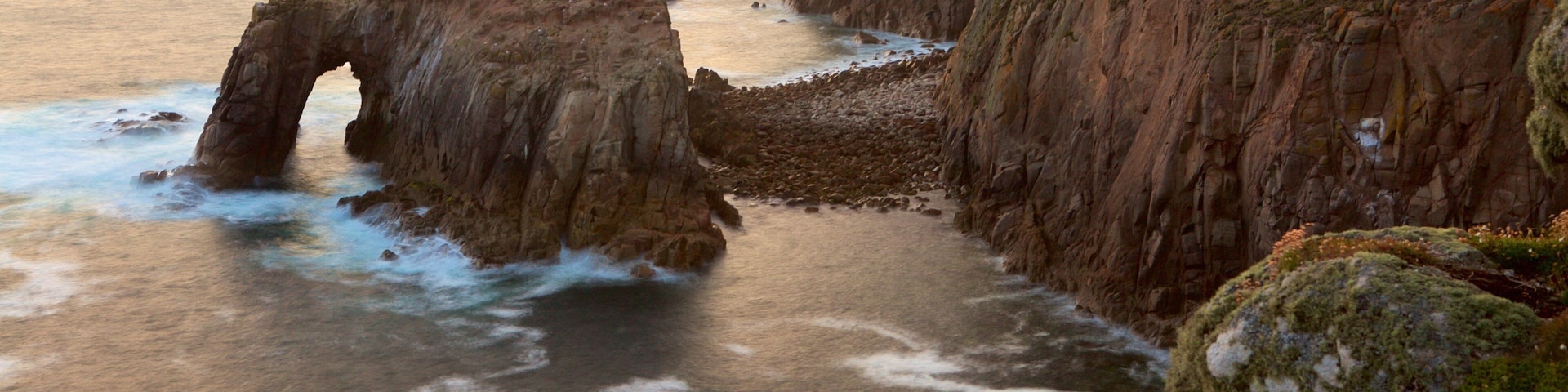 Land\'s End featuring a sunset, rocky coastline and general coastal views
