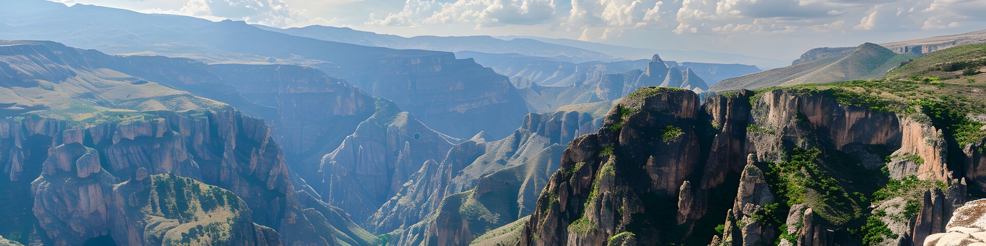 Paisagem de cânion com penhascos íngremes e céu claro.