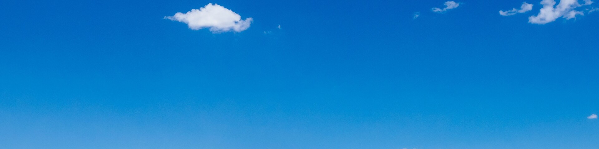 Um pagode tradicional com vários andares, céu azul límpido e montanhas ao longe.