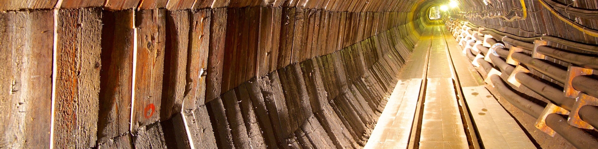 Um túnel de madeira com um banco de madeira ao lado.
