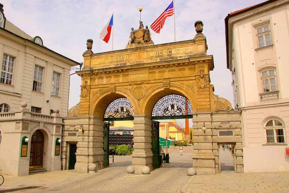 Um arco ornamentado com bandeiras, uma bicicleta e edifícios.