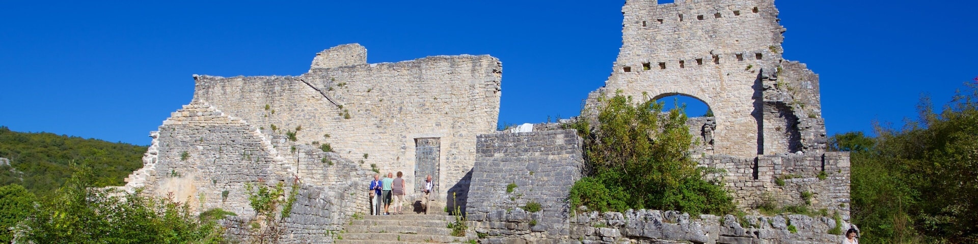 Uma estrutura antiga de pedra com uma grande porta em arco e uma torre.
