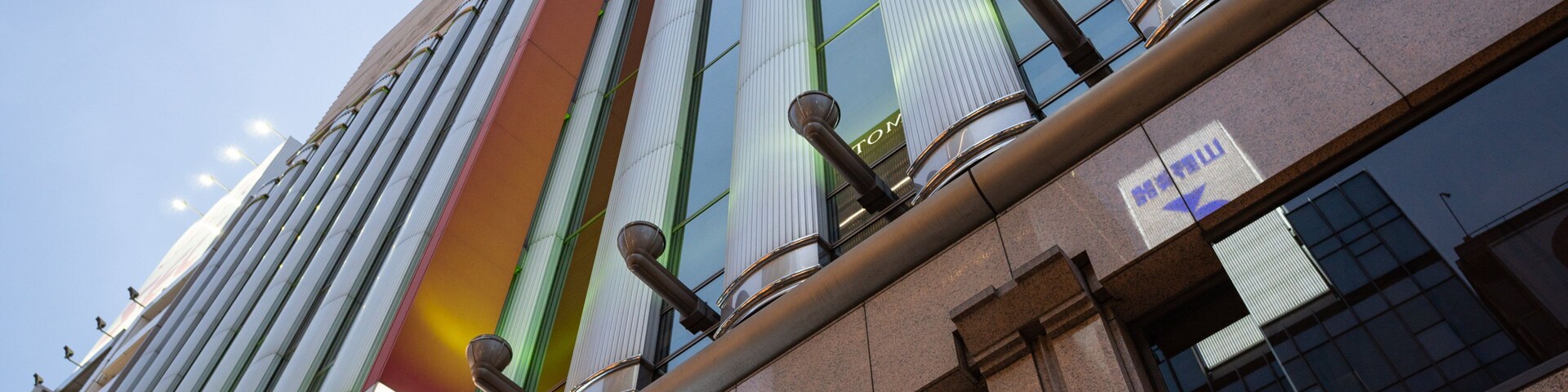 Um edifício moderno com janelas de vidro refletivas e um logotipo em destaque.