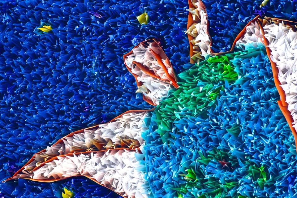 Uma tartaruga estilizada com casco azul e cabeça verde, emoldurada por um fundo azul.