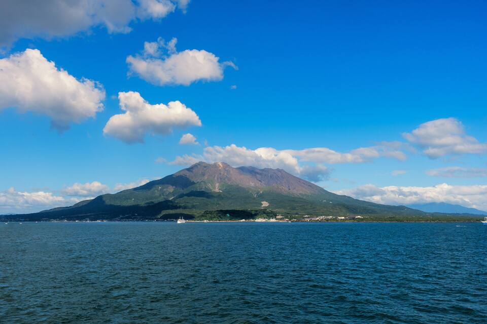 Uma montanha com um lago ao primeiro plano e um céu limpo.