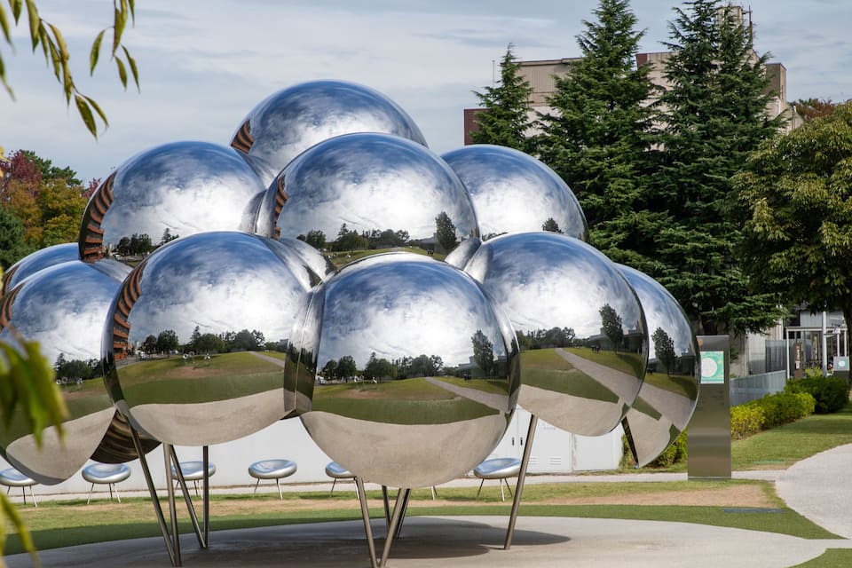 Um conjunto de esferas grandes e refletoras em ambiente externo.