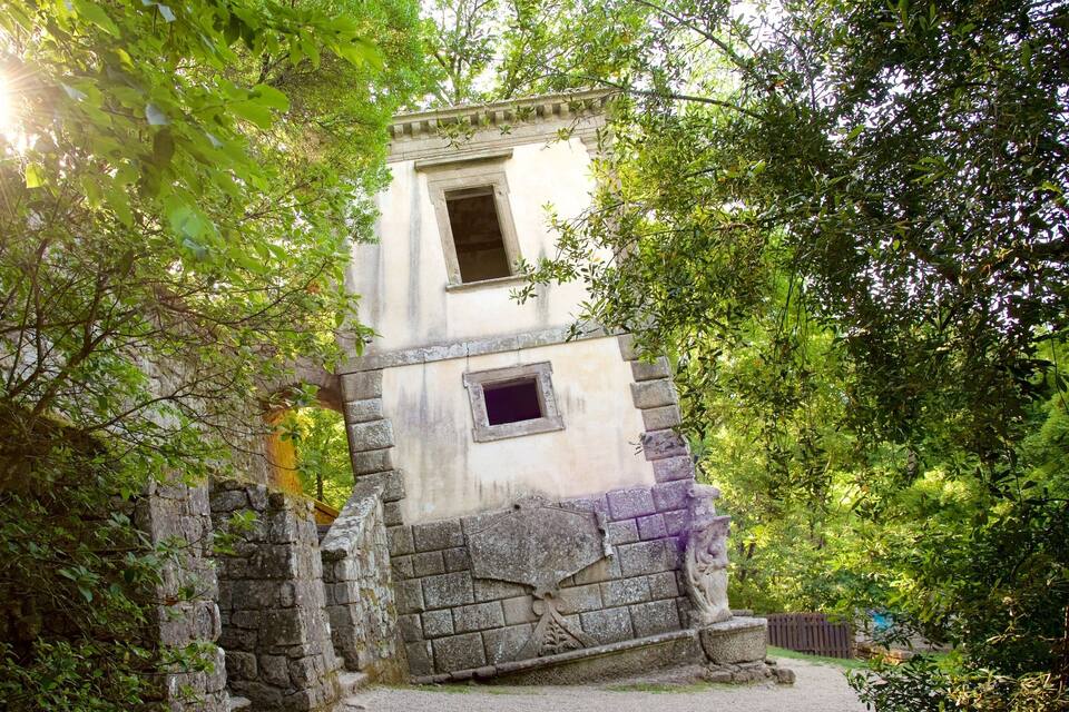 Um antigo edifício de pedra cercado por folhagem verde exuberante.