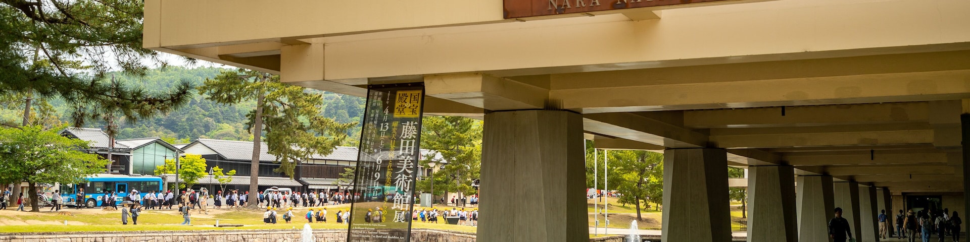 Entrada do Museu Nacional em Tóquio, Japão, com um caminho de pedra que leva a um lago e uma fonte.