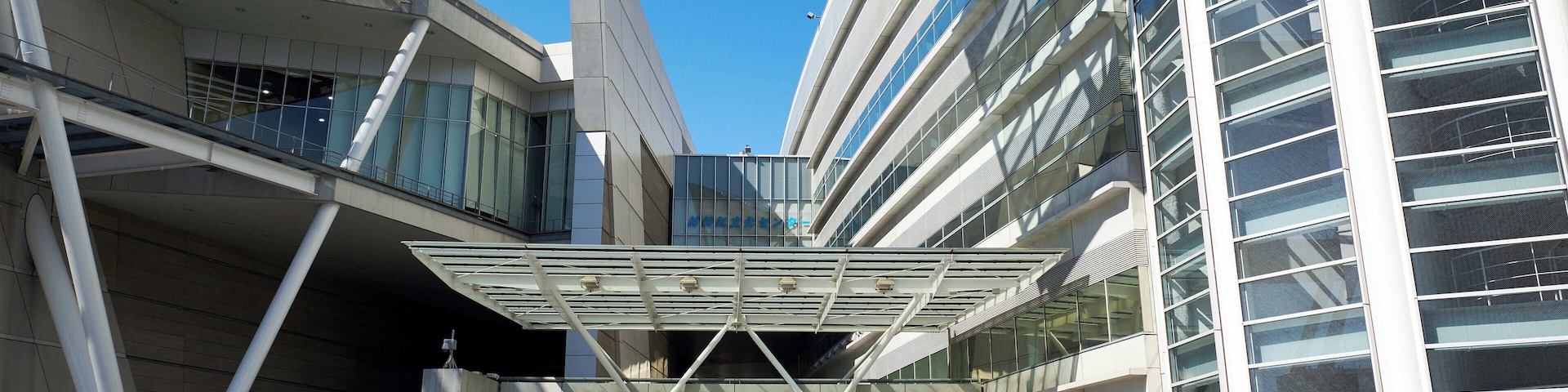 Uma estrutura arquitetônica moderna com uma placa que diz 'SAITAMA SUPER ARENA'.