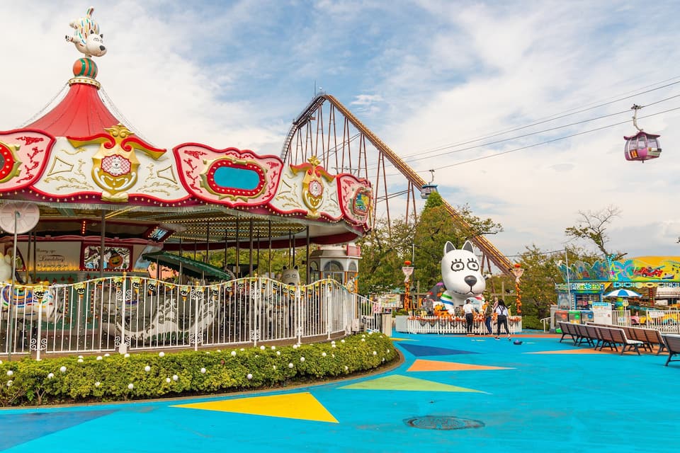 Um carrossel, uma montanha-russa e uma roda gigante em um parque de diversões.