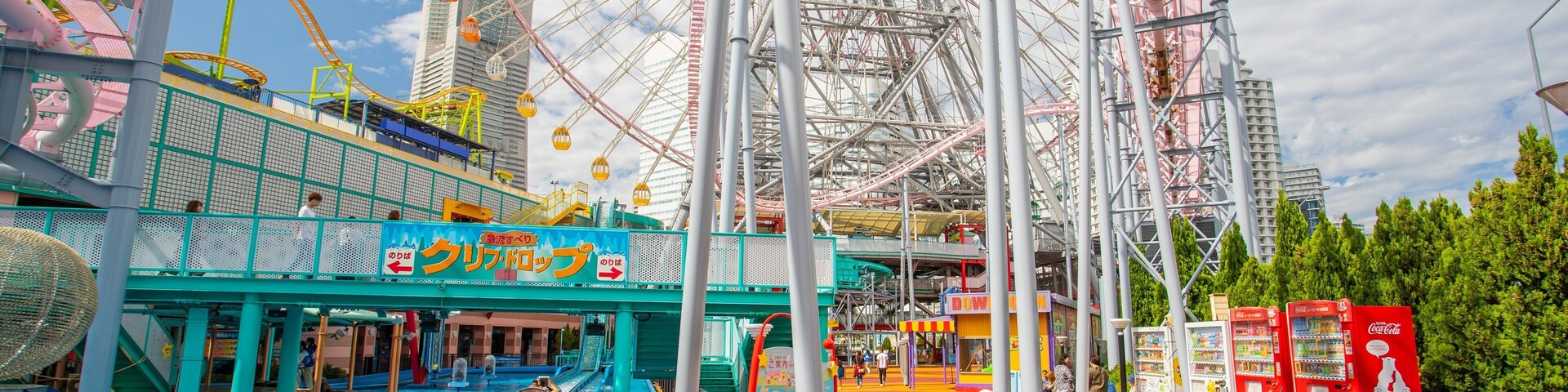 Uma roda gigante, uma montanha-russa e uma atração aquática em um parque de diversões.