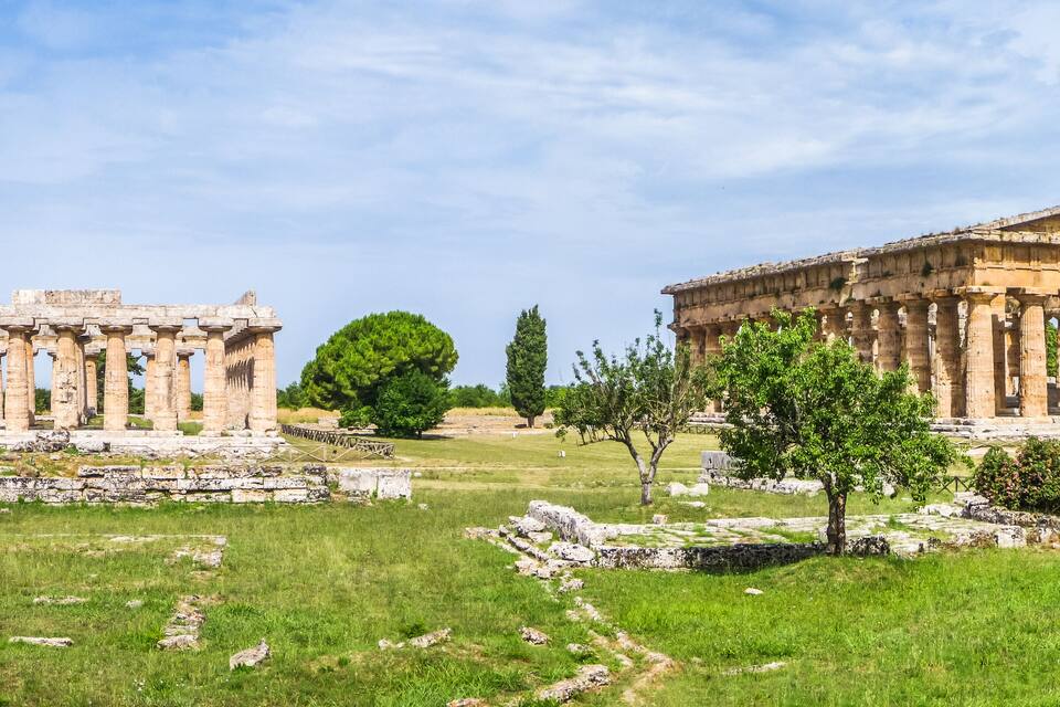 Ruínas gregas antigas com colunas e um templo.