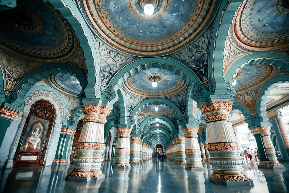Interior ornamentado com desenhos complexos no teto, colunas e uma estátua central.