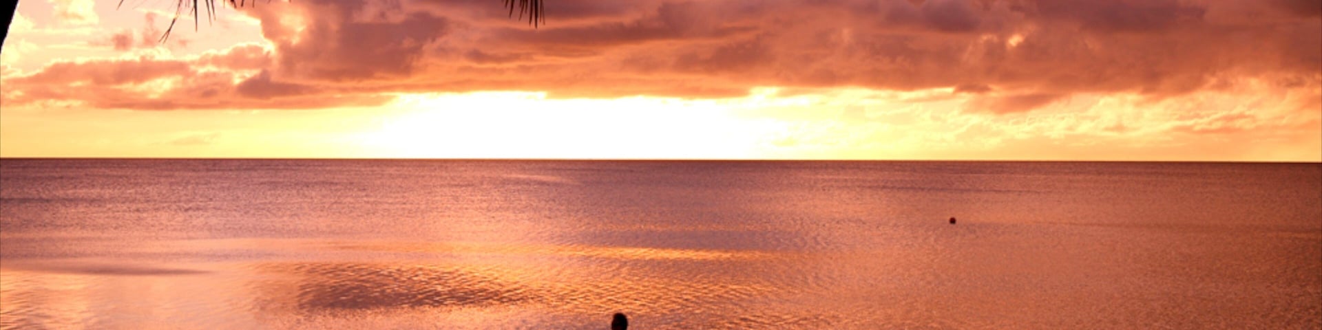 Tumon Beach which includes a sunset and a beach as well as an individual male