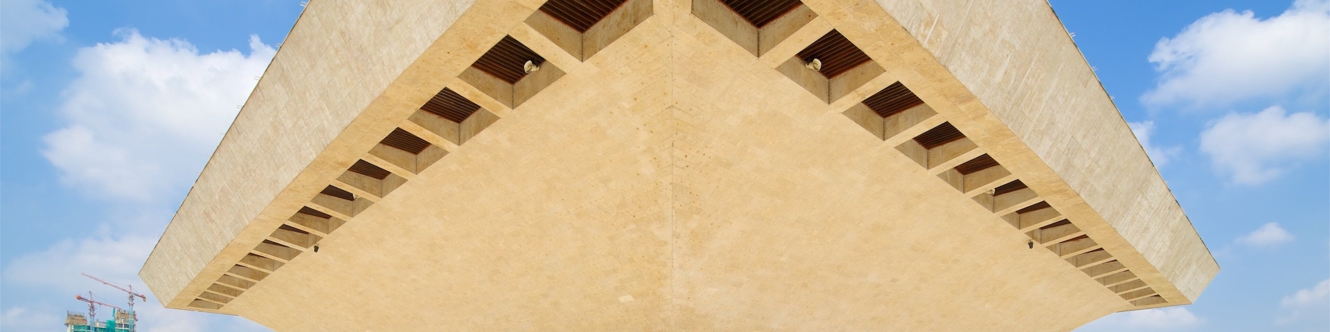 Uma grande estrutura de concreto triangular com telhado plano e várias aberturas de ventilação.