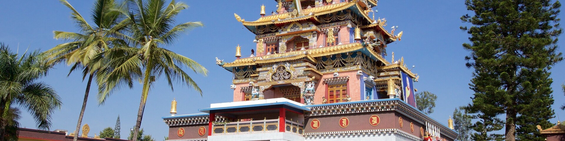 Um templo com vários níveis, decoração dourada elaborada e uma alta torre de sinos.