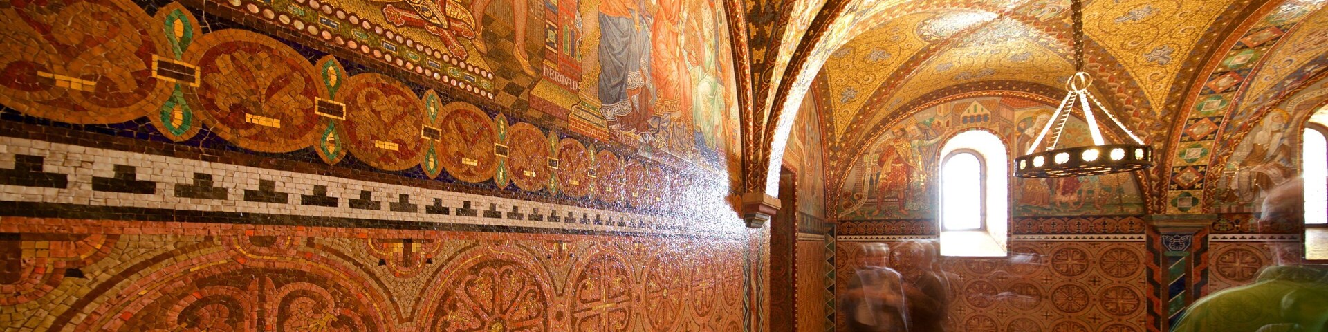 Interior ricamente decorado com mosaicos elaborados e arcos.