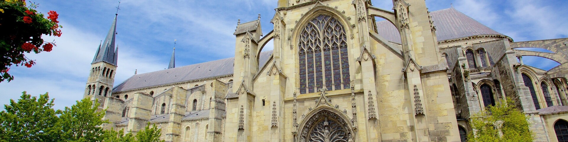 Uma catedral histórica com uma grande janela rosácea e uma torre alta.