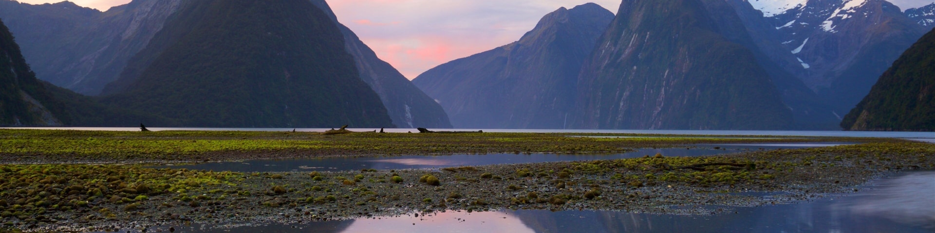 Mitre Peak which includes a pebble beach, a lake or waterhole and a sunset