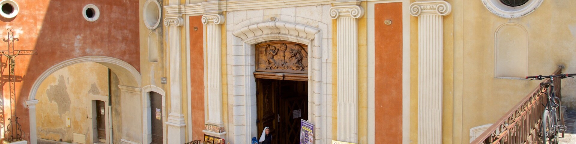 Um edifício histórico com entrada central, colunas e um campanário.