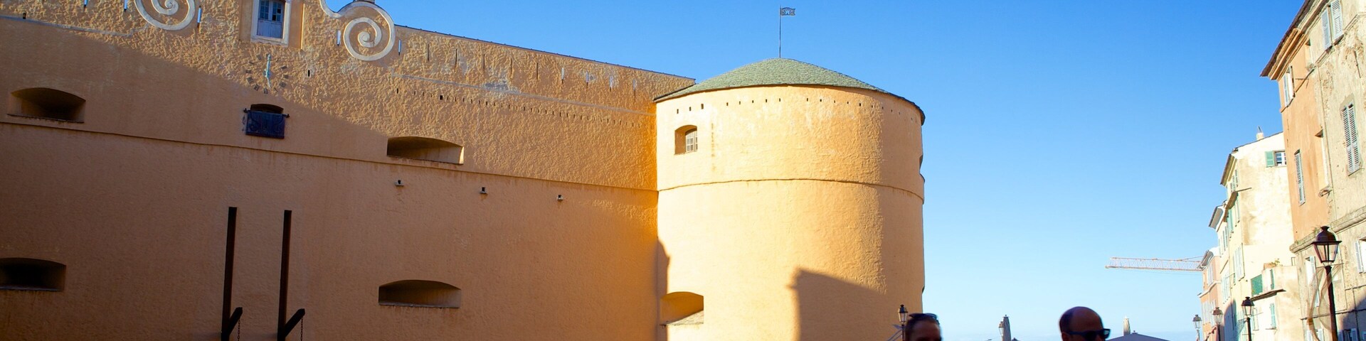 Um edifício histórico com uma torre de relógio e uma torre redonda.