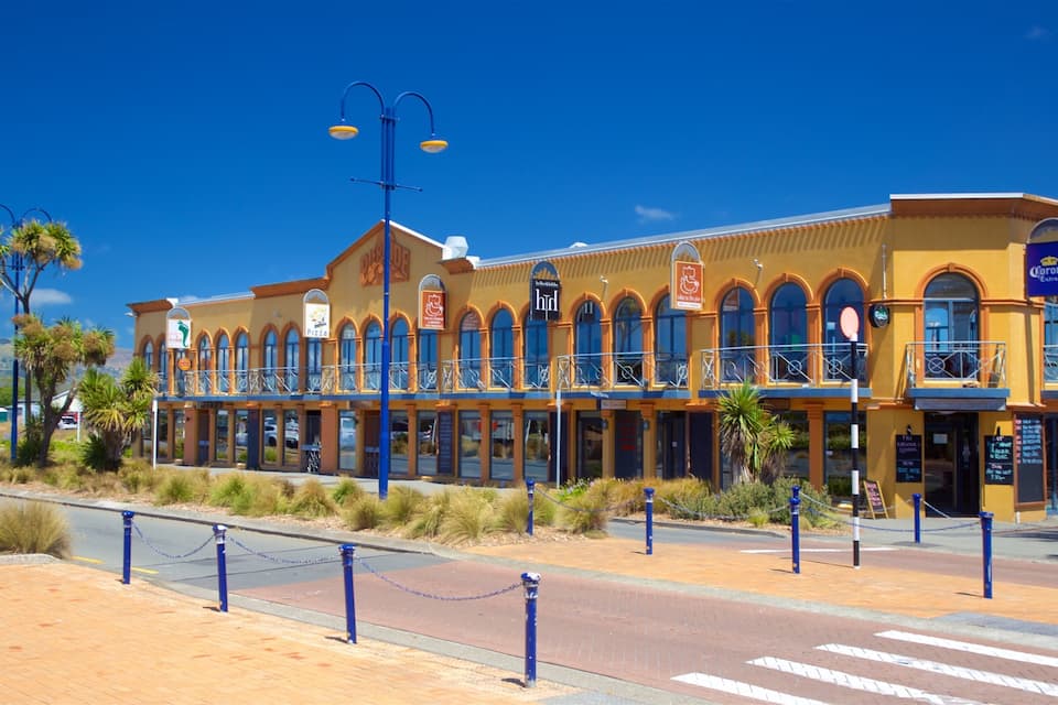 Um edifício amarelo com janelas em arco e um letreiro da 'Pizza Hut'.