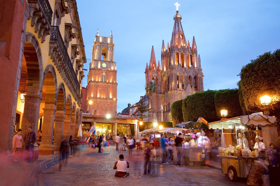Uma praça movimentada com edifícios históricos, uma catedral imponente e bancas de mercado.