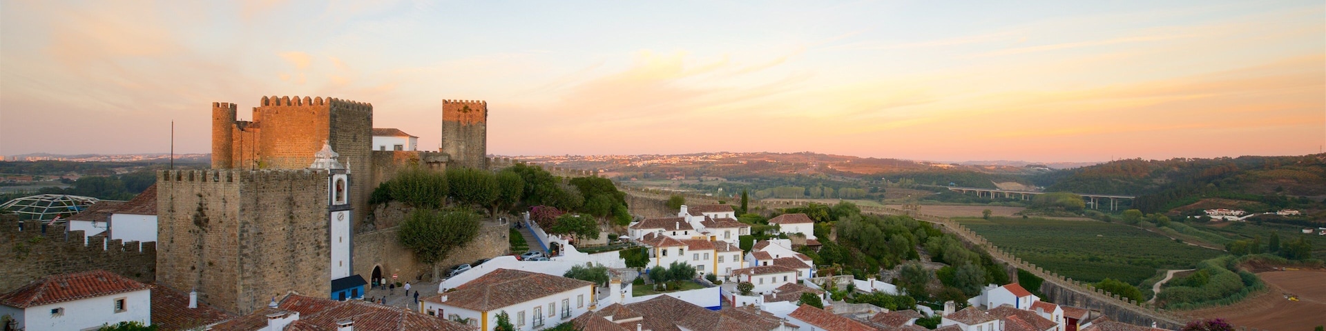 Obidos Castle which includes landscape views and a sunset