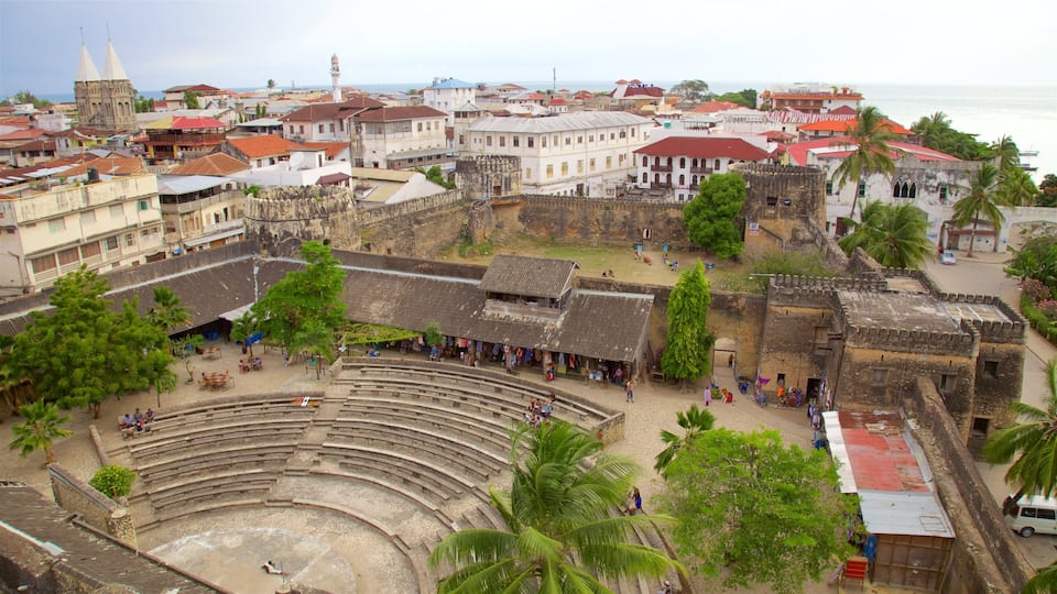 Um anfiteatro rodeado por edifícios históricos e palmeiras.
