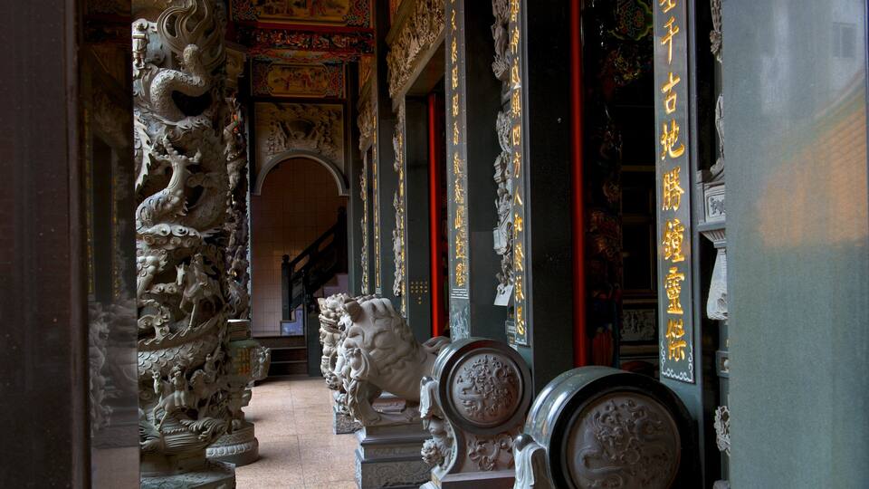 Um corredor ornamentado com esculturas elaboradas e inscrições douradas.