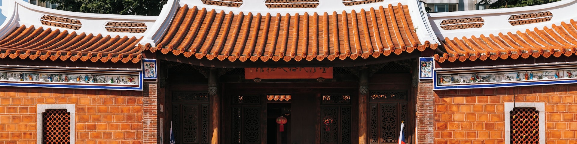 Um edifício tradicional chinês com telhados vermelhos ornamentados e elaboradas esculturas em madeira.