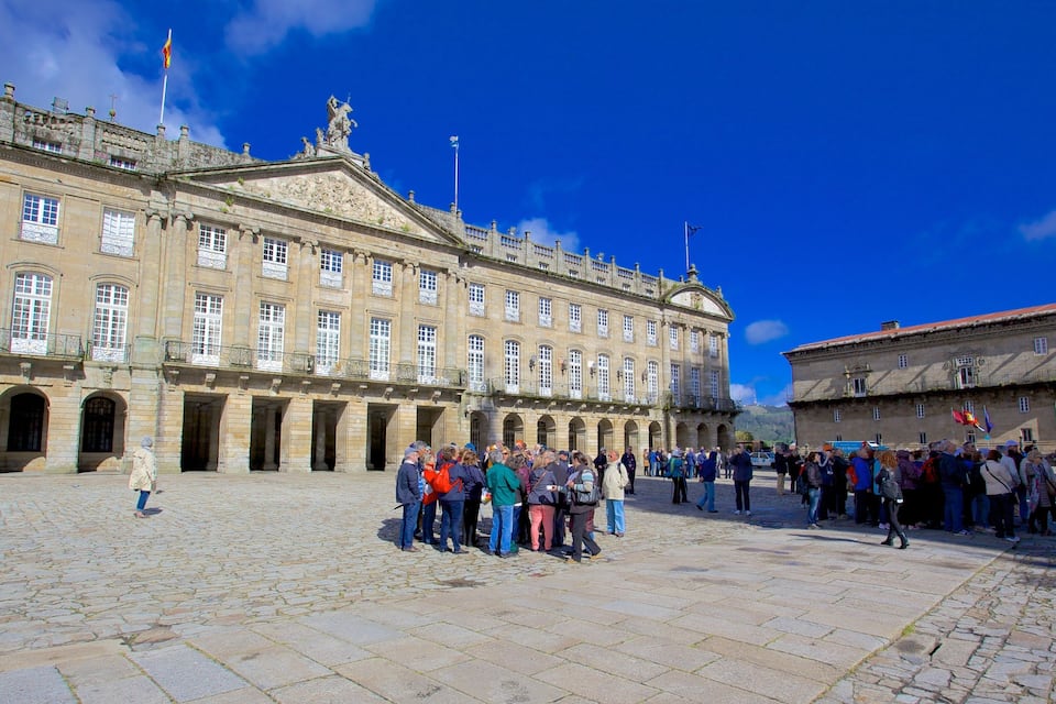 Um edifício histórico com um amplo pátio aberto e uma multidão de pessoas.